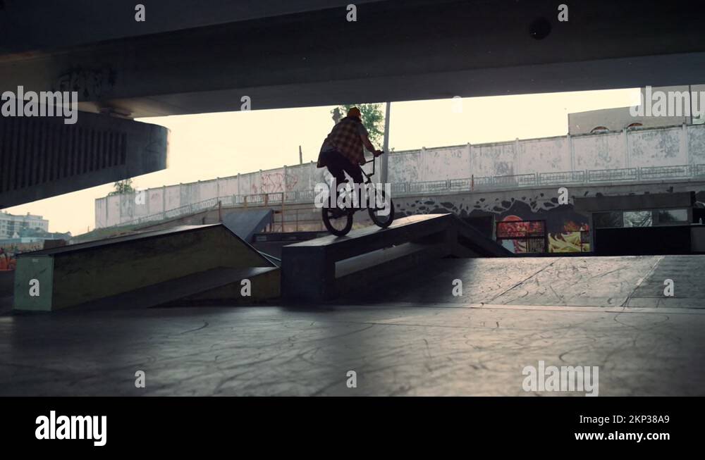 Extreme teenage man falling down while practicing jump stunt on bicycle ...