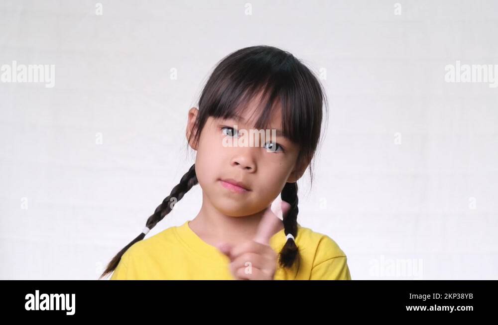 A school girl showing a trembling finger gesture saying no on white ...