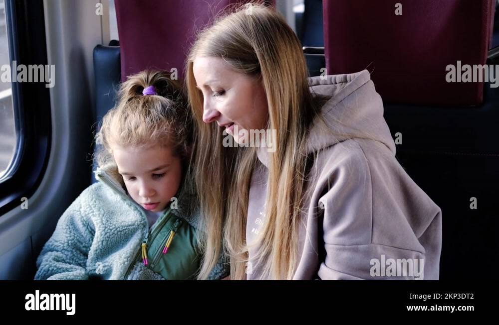 Mom Helps Her Daughter Draw A Picture While They Are On The Train Stock