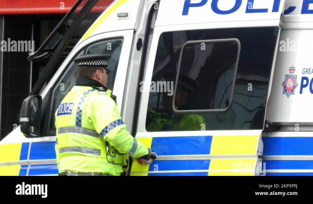 Greater Manchester police officer opening van talking to colleague as tram Stock Video Footage ...