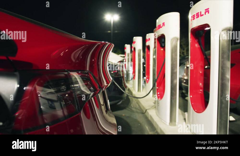 Tesla cars at Tesla Supercharger at night, Red modern innovative SUV ...