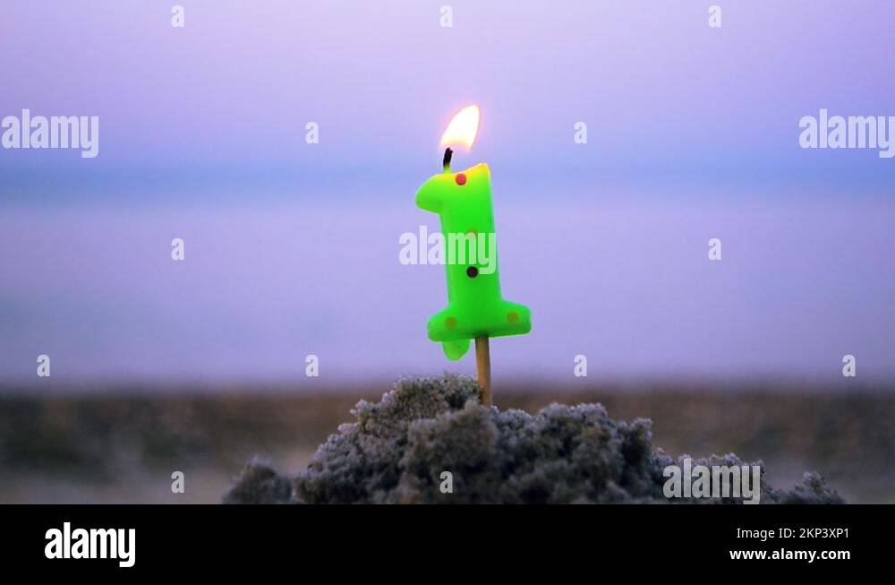 Candle number one inserted sand and burns. Lighted candle in sand on ...