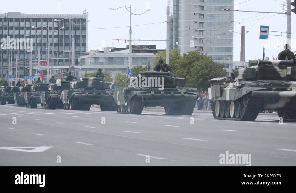Column of T 72 B tanks with soldiers rides along city street, view from ...