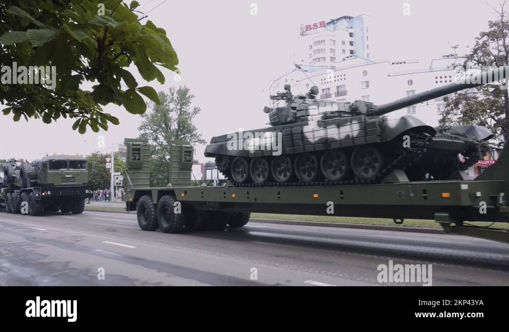 Column of military four-wheel drive tractors transport tanks on open ...