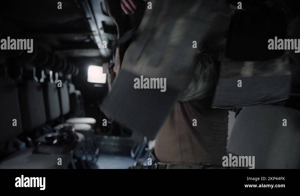 Special forces sniper in an armored military vehicle, puts on a ...