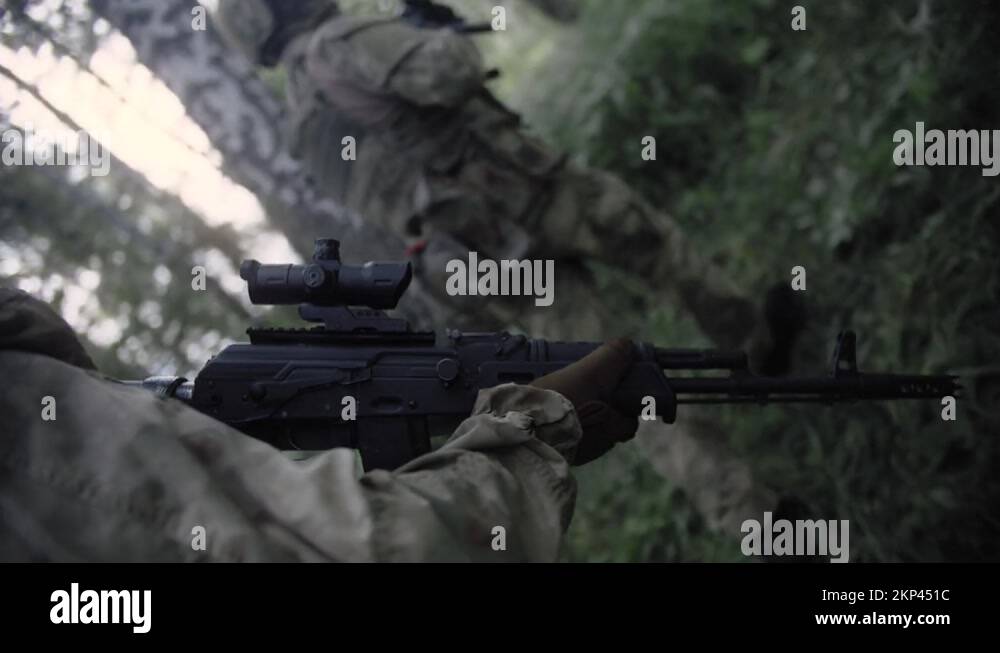 Group soldiers, with automatic rifles in their hands, in the dense ...