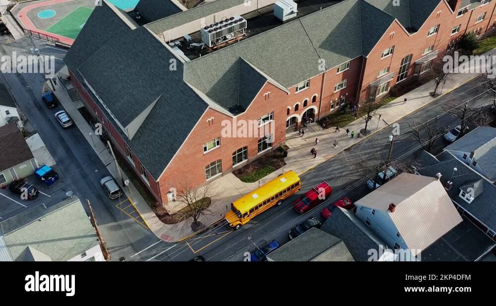 Modern American school building with school bus drop off. Playground ...