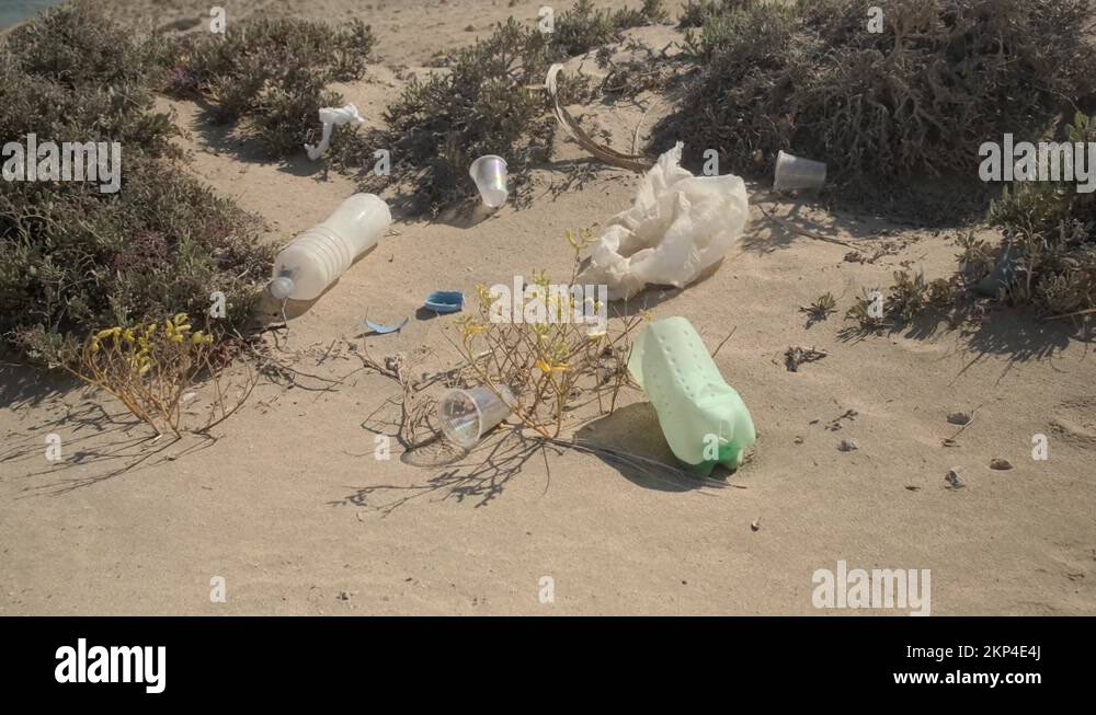 Plastic trash in the desert. Plastic pollution in a sandy desert in ...