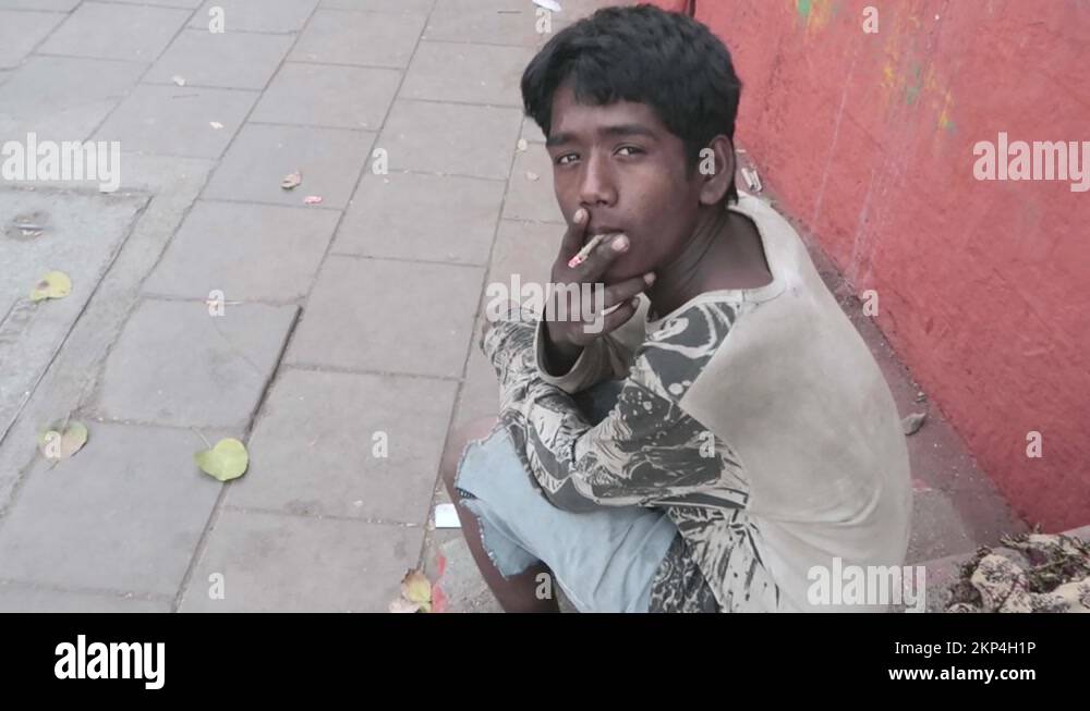 Young Indian Homeless male boy sitting and smoking cigarette ...