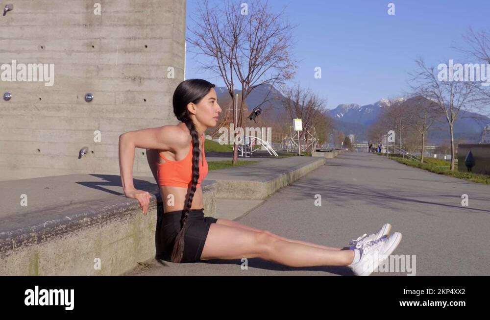 Young Hispanic woman doing triceps dip exercise on cement stair, Side ...