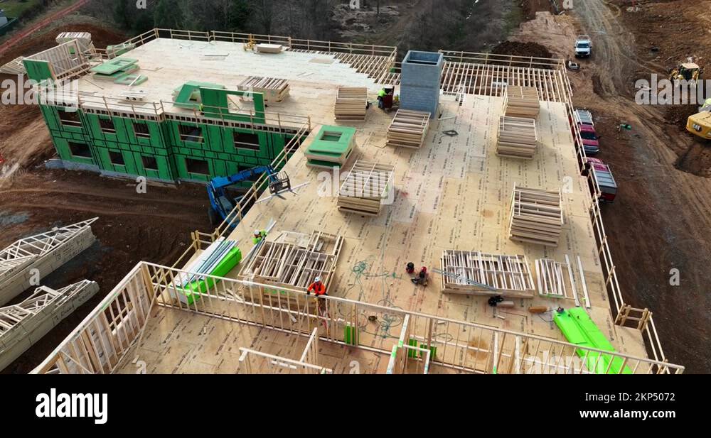 Construction worker installs wooden prefab wall framing. Wooden lumber ...
