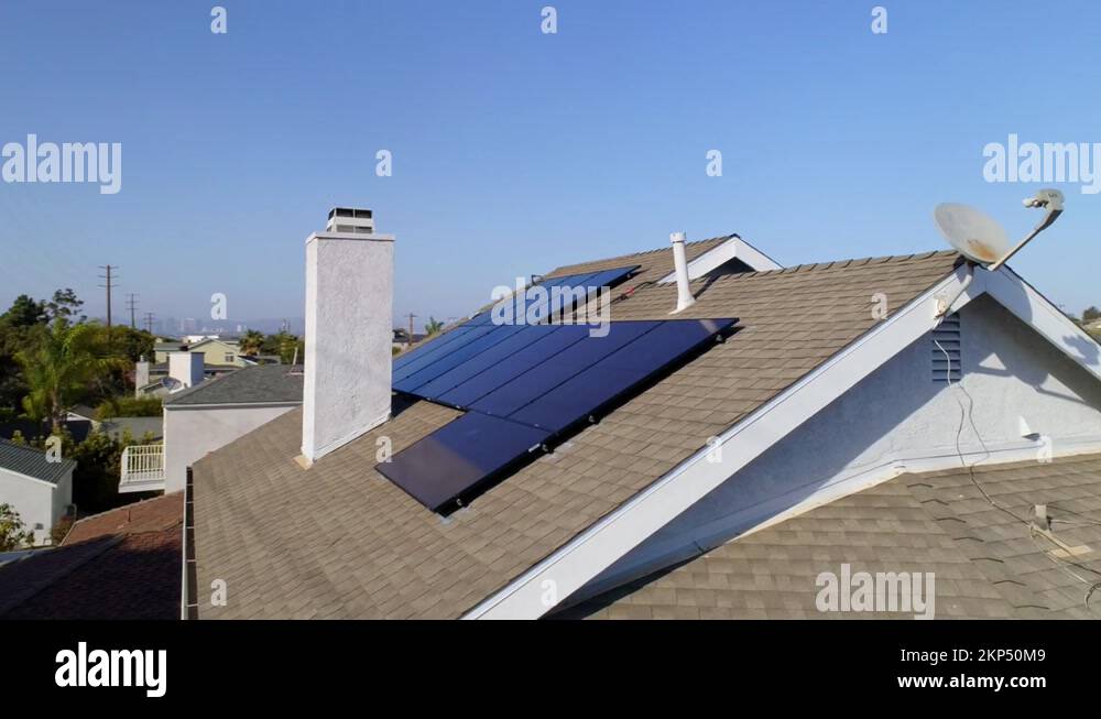 Orbit around the back of a house rooftop with multiple solar panels ...