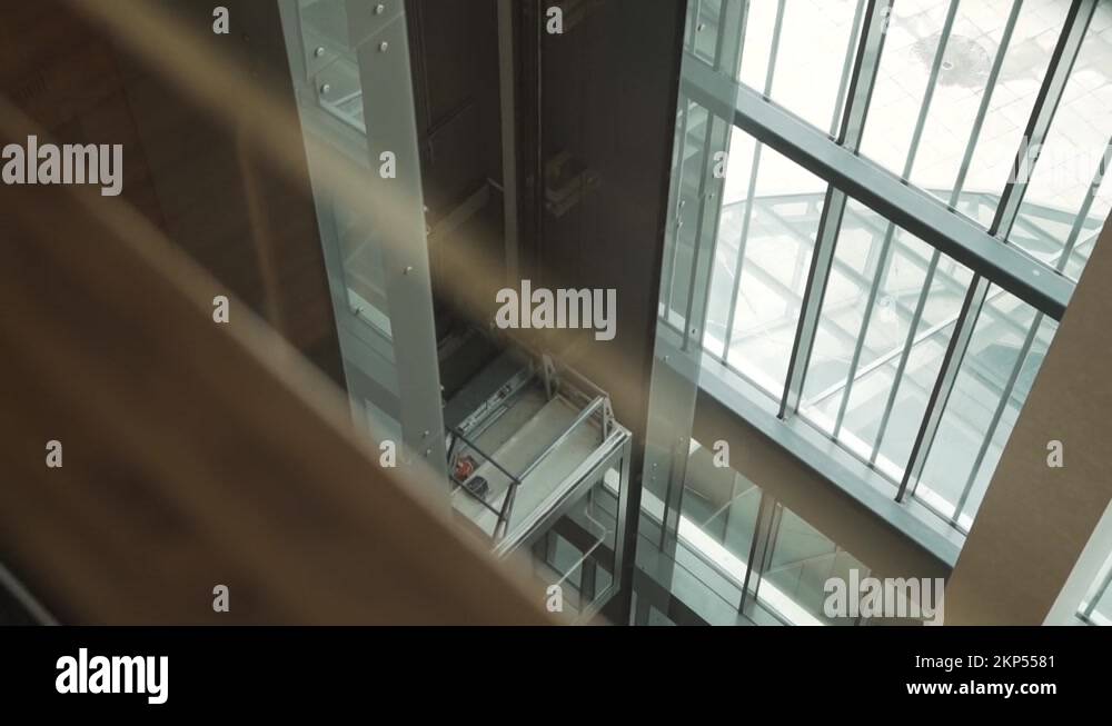 Open glass transparent elevator car rises up inside the building Stock ...