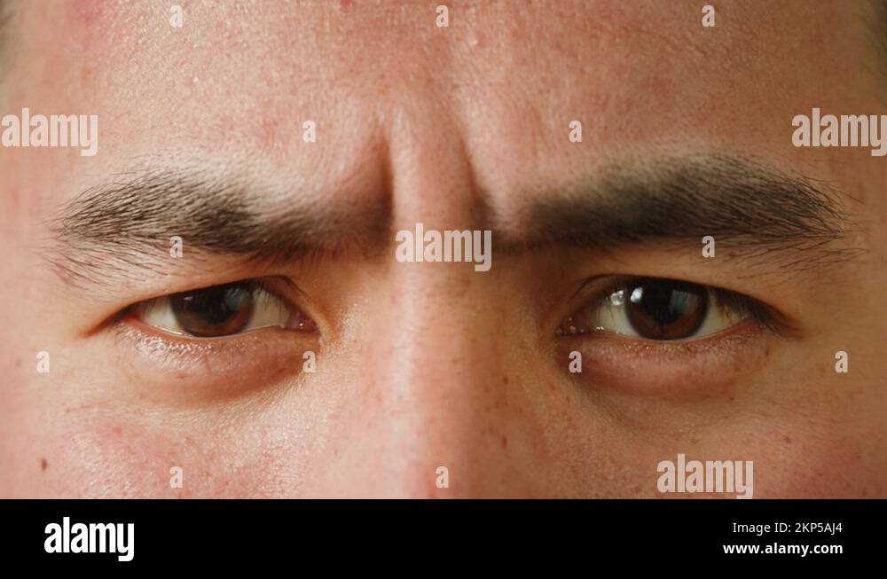 Asian angry man eyes close-up. Half-face portrait of Korean young guy ...