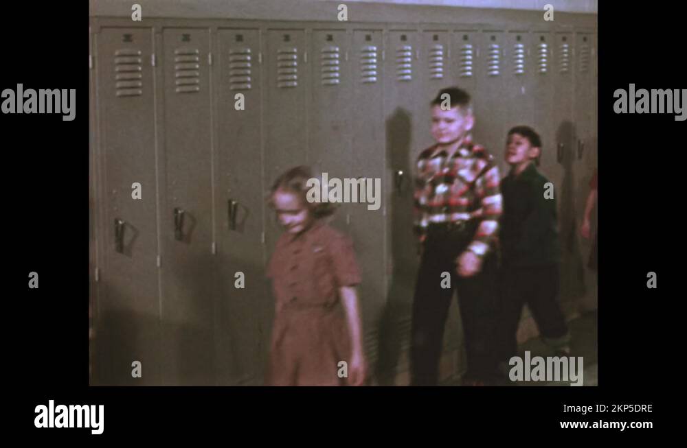 1950s: children walk single file past lockers in school hallway ...