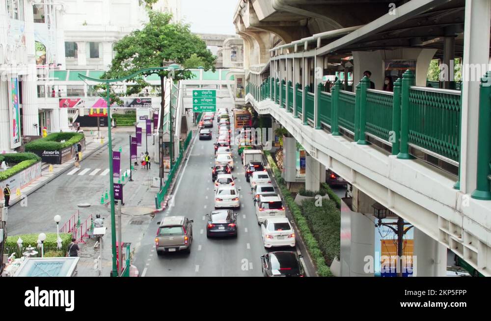 People walking on the skywalk above Traffic through busy intersections ...