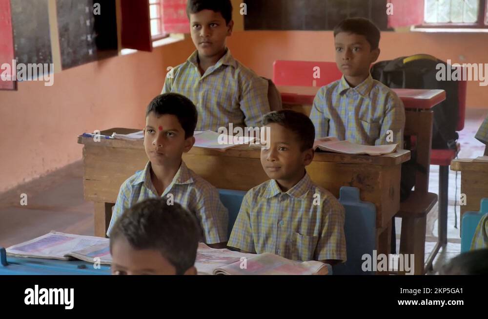 Indian Rural School children sitting on bench in classroom during ...