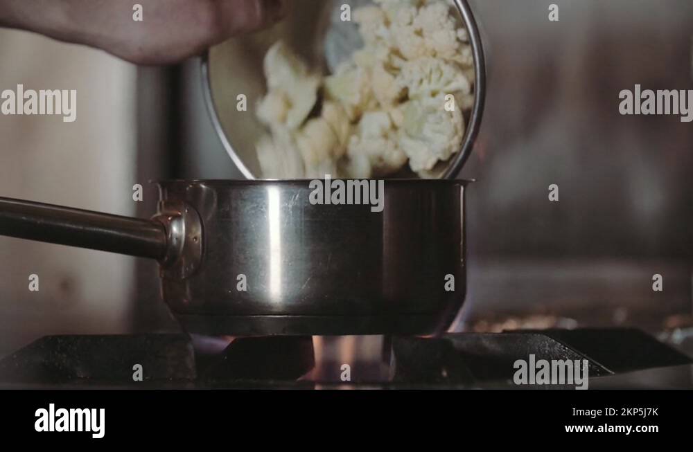 Chef is Putting vegetables into boiling water, Cauliflower into boiling ...