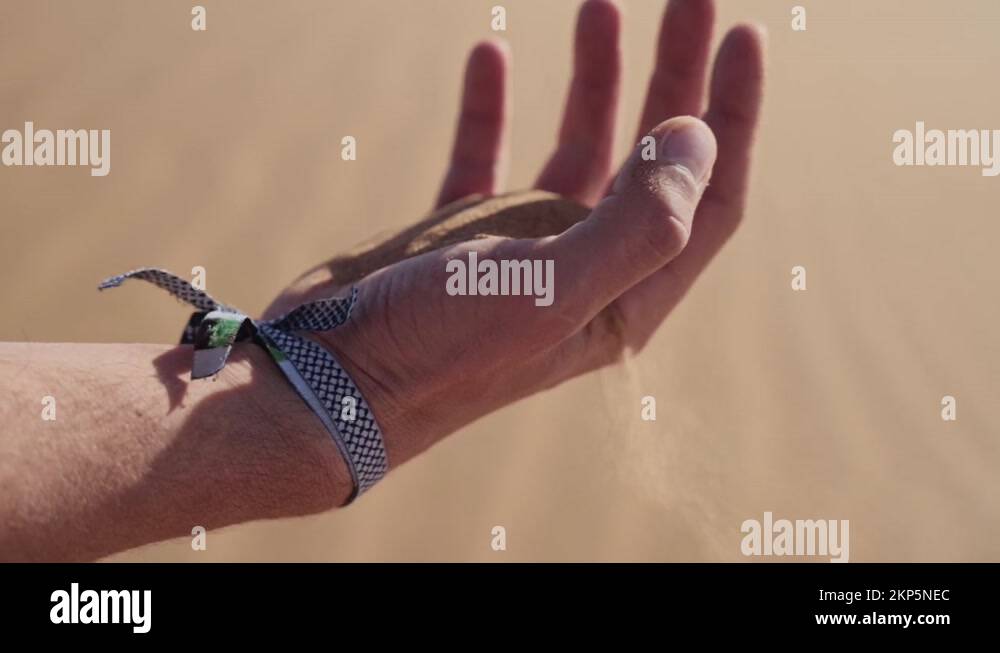 Dry sand of Sahara desert particles falling from person hand and fly in ...