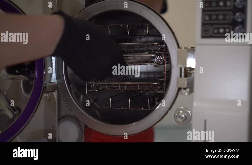 Woman puts a packaged instrument into an autoclave Stock Video Footage ...