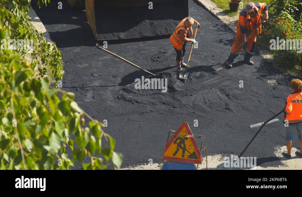 Road street repairing works. Construction workers during asphalting ...