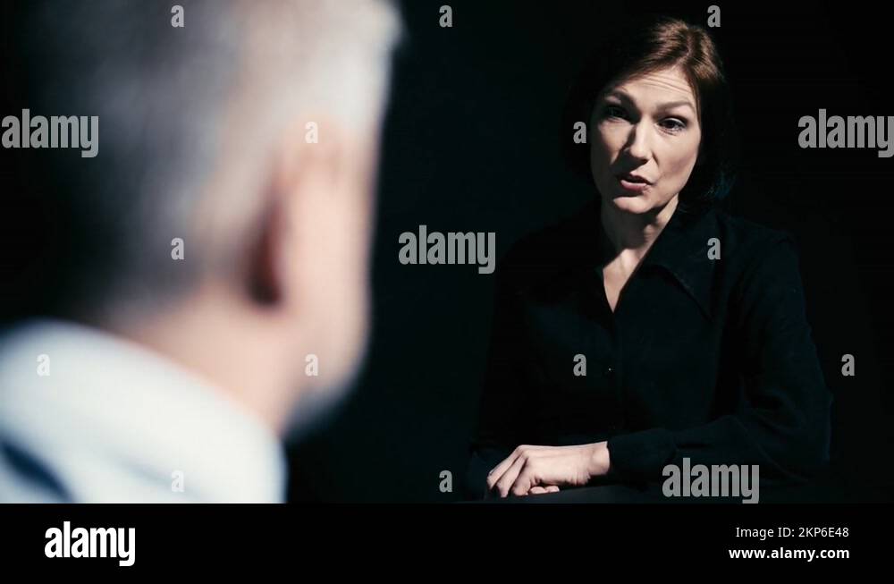 Police interrogation scene, detective showing photos of crime scene to ...