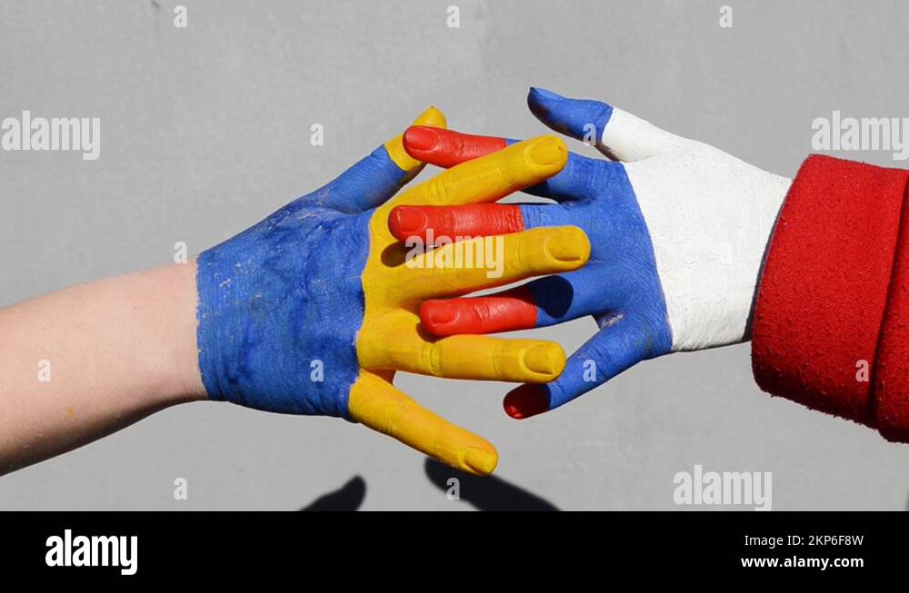 hands of russian and ukrainian flags colors, symbol of truce and ...