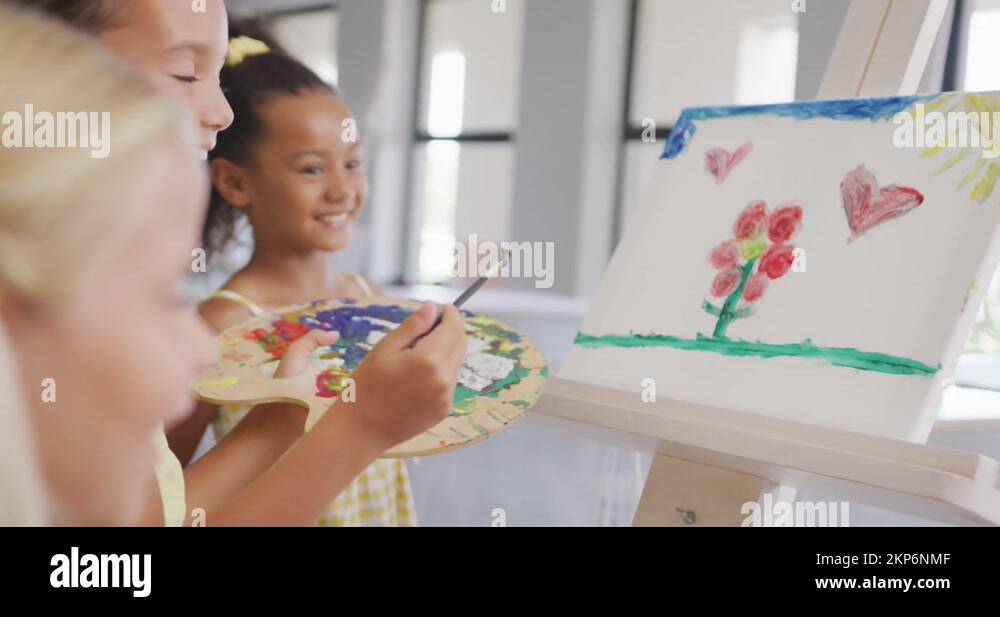 Video of happy diverse girls painting during art lessons at school ...