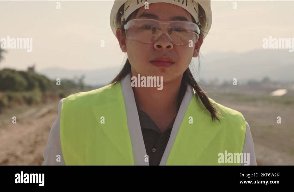 Female civil engineer wearing a white helmet works at a dam ...