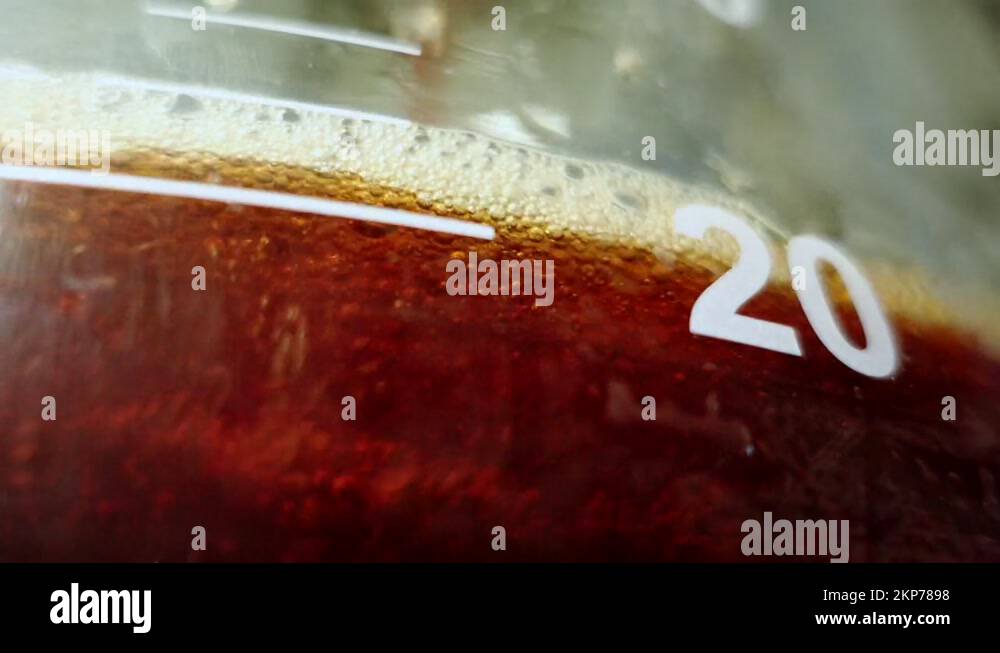 Close-up of the boiling chemical liquid inside of the glass beaker ...