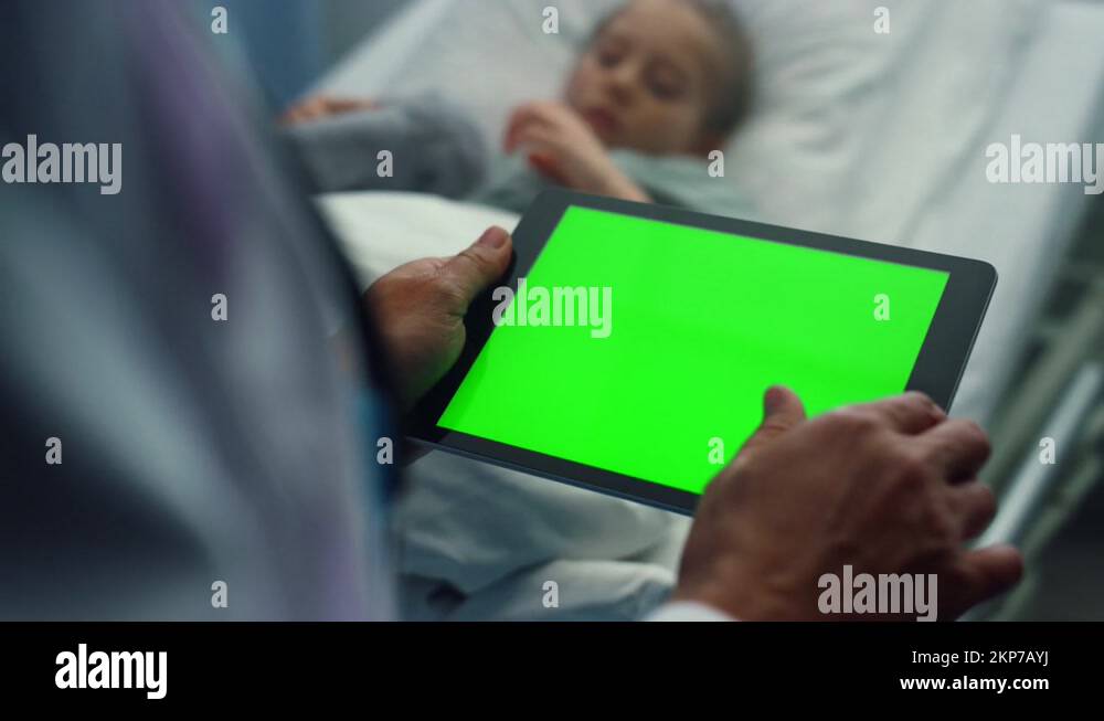 Doctor touching tablet green screen closeup. Sick girl lying in ...