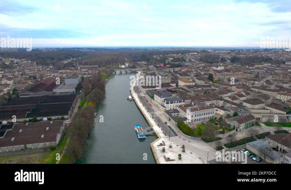 Boat pier, town center and the Hennessy Liquor Distillery on Charente ...