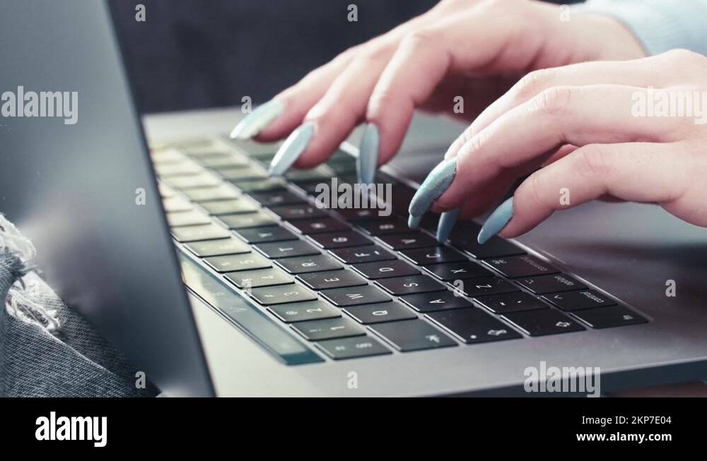 Secretary hands with long nails typing on modern keyword laptop device ...