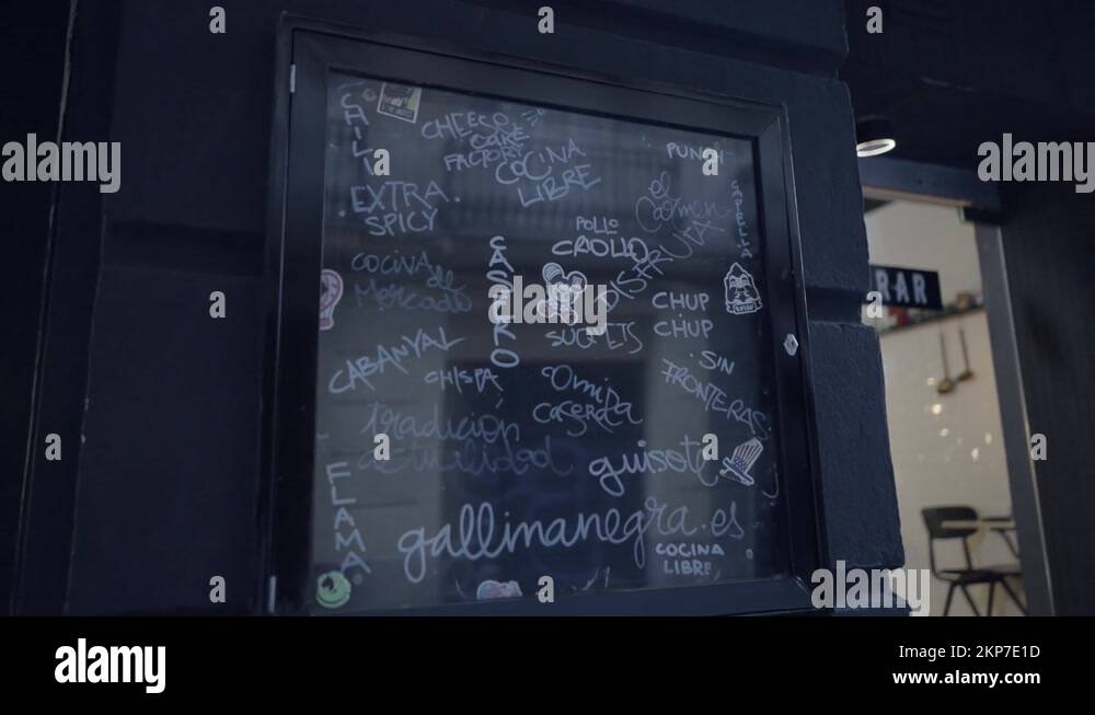 Slow pan of glass sign with messy text on exterior wall of restaurant ...