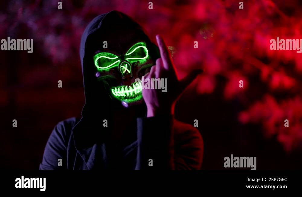 portrait of a person in a terrible glowing mask of death and in a hood ...