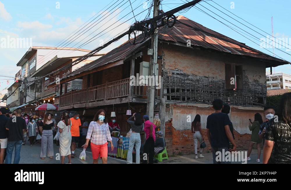 People walking around this street corner while a woman goes to a brick ...
