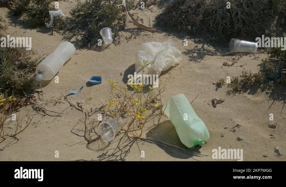Plastic trash in the desert. Plastic pollution in a sandy desert in ...