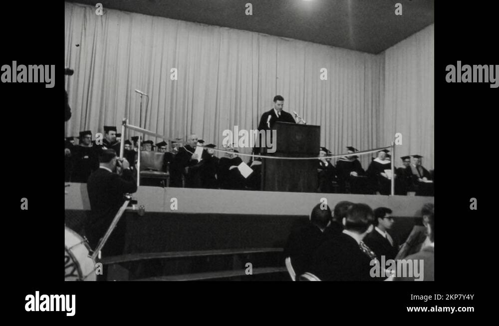 1960s: People sit on stage in caps and gowns, man stands at podium with ...