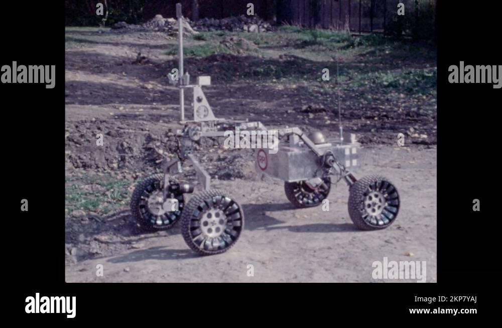 1970s: Robotic vehicle driving on dirt path. Rover adjusting wheels ...