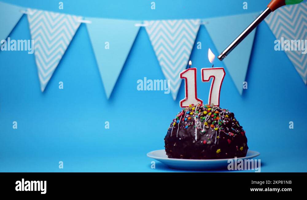 chocolate birthday cake with a burning candle number seventeen, 17 on a ...