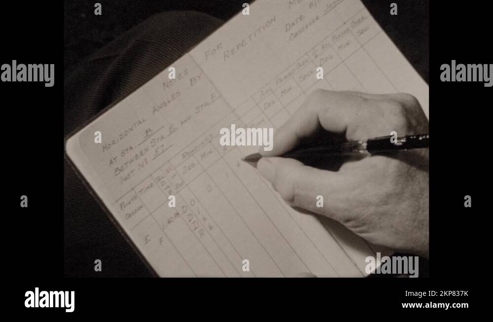 1960s: Man making notes in notebook of angles. Degrees on scale of ...