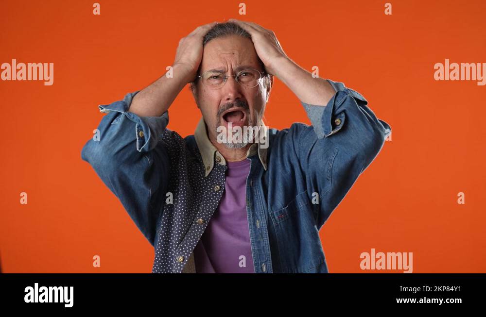 Displeased irritated sad angry elderly bearded man 50s 60s cover ears ...