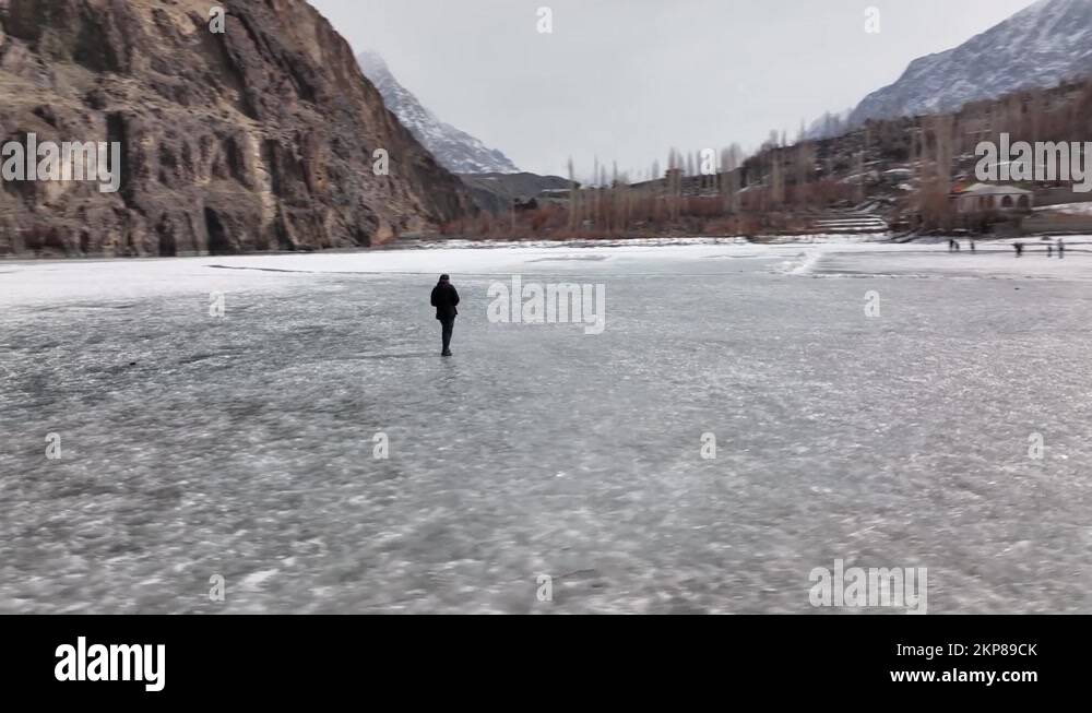 Cinematic. A teenager walks on ice in a blizzard at khalti lake . Bad ...