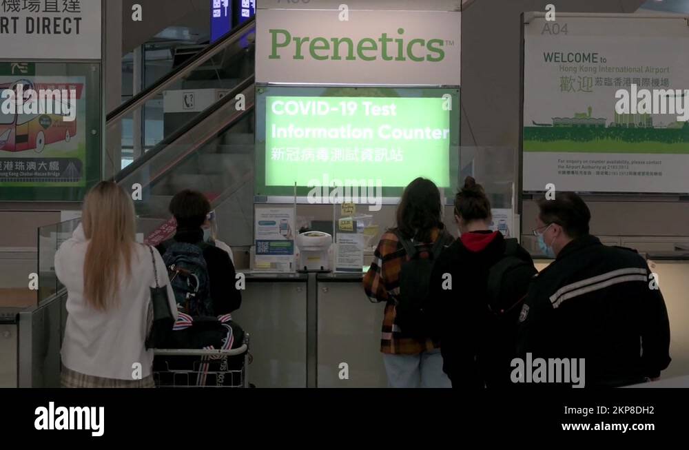 Workers are seen at the Covid-19 test information counter at Chek Lap ...
