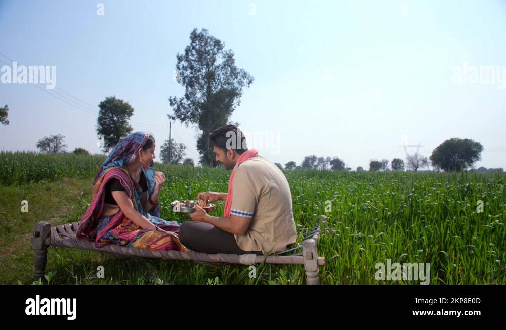 Two Indian farmers / workers eating food / lunch together after working ...
