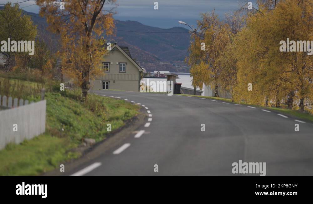 A narrow road goes through the coastal village. Neat fences and houses ...