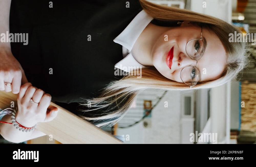 Vertical screen: Smiling waitress girl in empty restaurant when it's ...