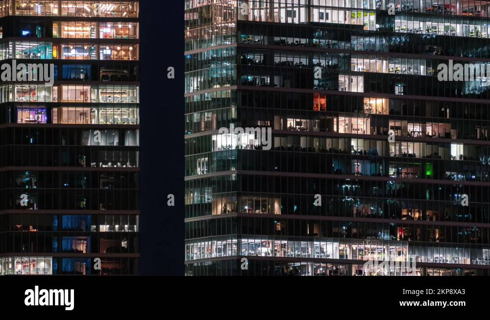 Blinking office window lights in business center skyscraper people work ...
