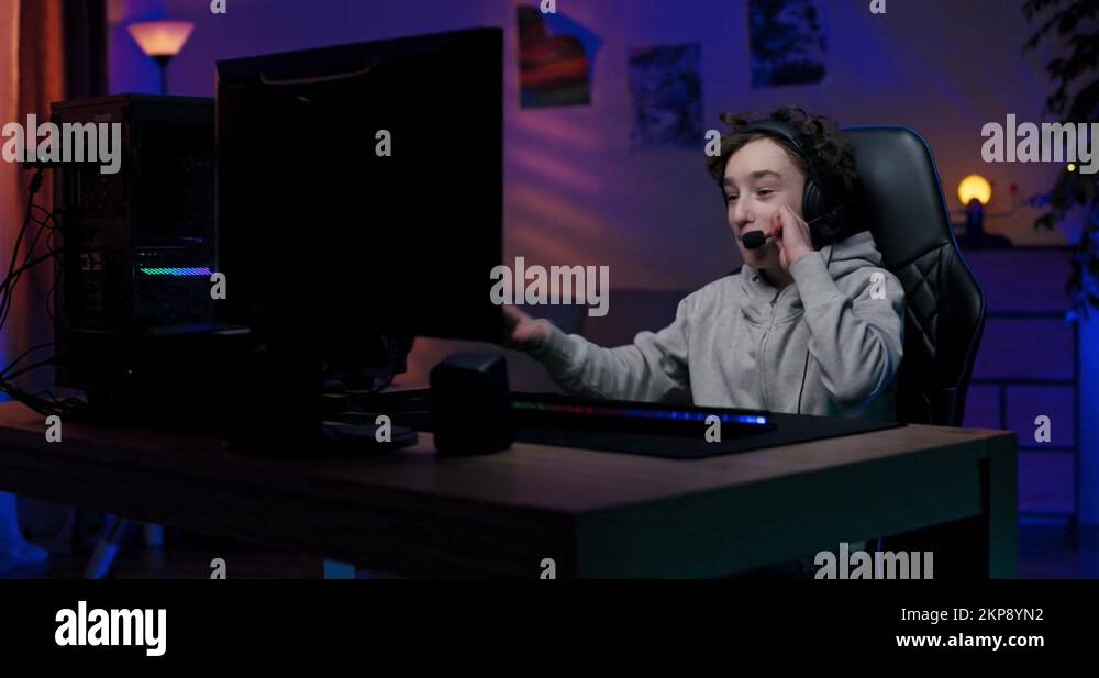 Child pro gamer spends time in front of monitor playing computer games ...