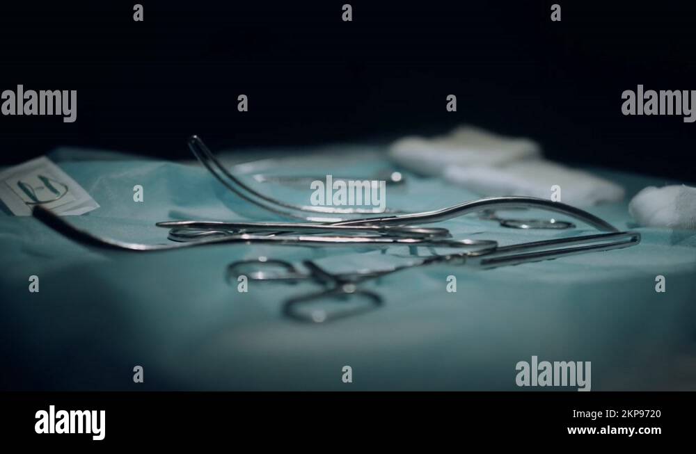 Table with surgical instruments in dark sterile operating room side ...